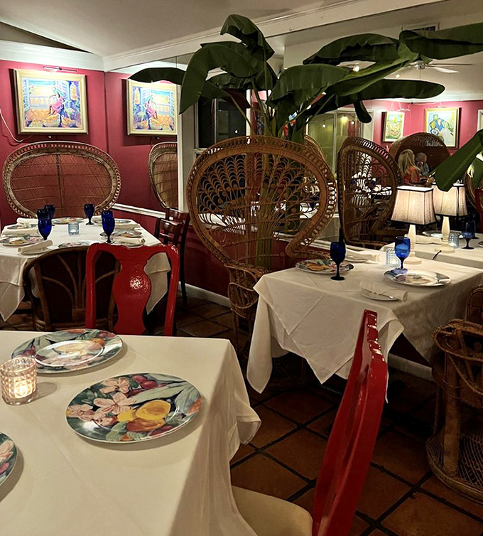 Peacock-style wicker chairs and lush plants create a dining room that feels like an elegant tropical getaway.