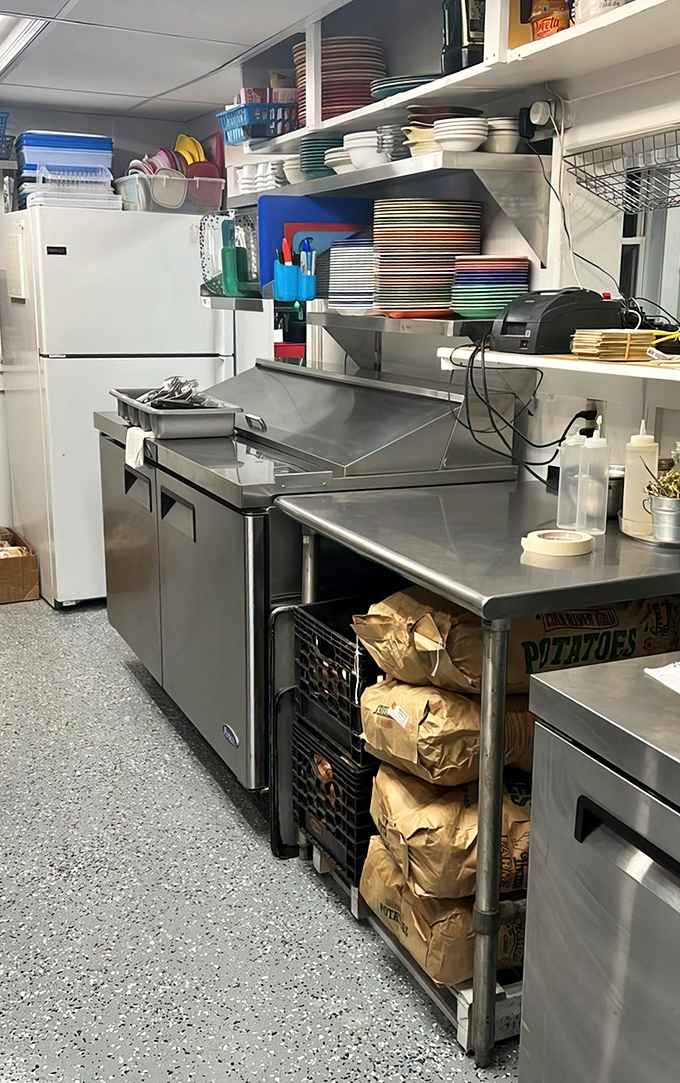 The organized chaos of a working diner kitchen, where colorful plates stack high and efficiency meets hospitality in the space where your breakfast gets its start.
