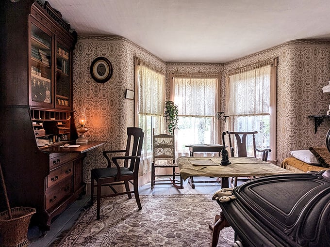 Patterned wallpaper and period furniture transform this room into a time capsule where you can almost hear the tick of a bygone era.