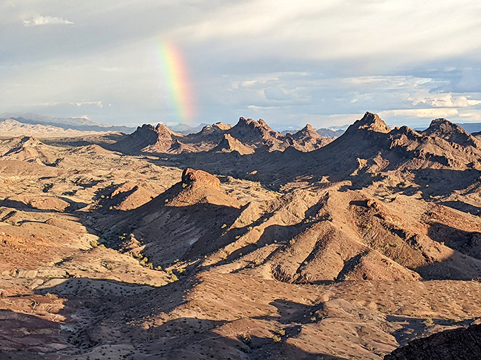 A rainbow kisses the rugged landscape, proving even the harshest terrain has its moments of unexpected tenderness.