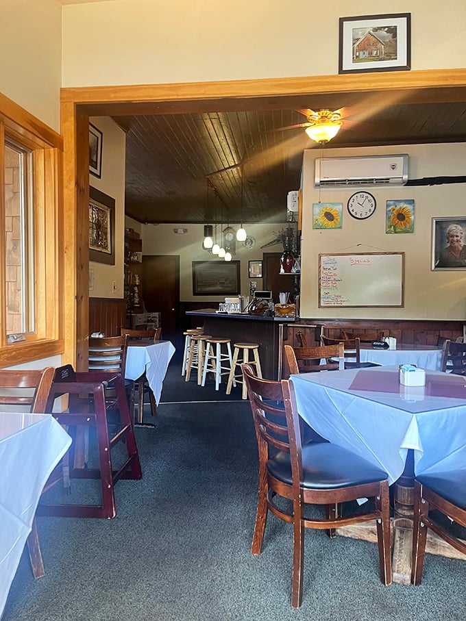The dining room's unpretentious charm comes from wooden wainscoting, local artwork, and tables set with care &ndash; no designer needed, just genuine Vermont hospitality.