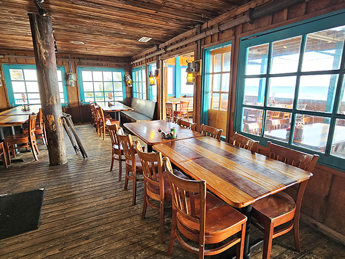 Wooden tables bathed in natural light from turquoise-framed windows create the perfect setting for lingering over lunch while watching waves roll in.