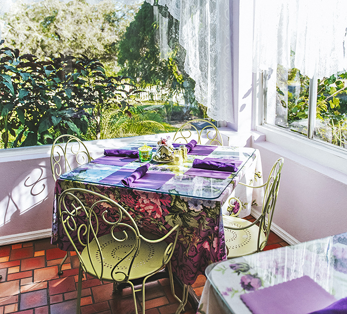 Sunlight streams through lace curtains onto a perfectly set table, creating the ideal setting for intimate conversations and memorable meals.