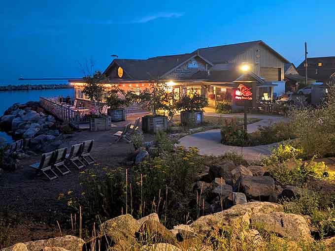 As evening falls, the caf&eacute; glows warmly against the darkening sky, promising cozy meals and spectacular sunsets over the water.