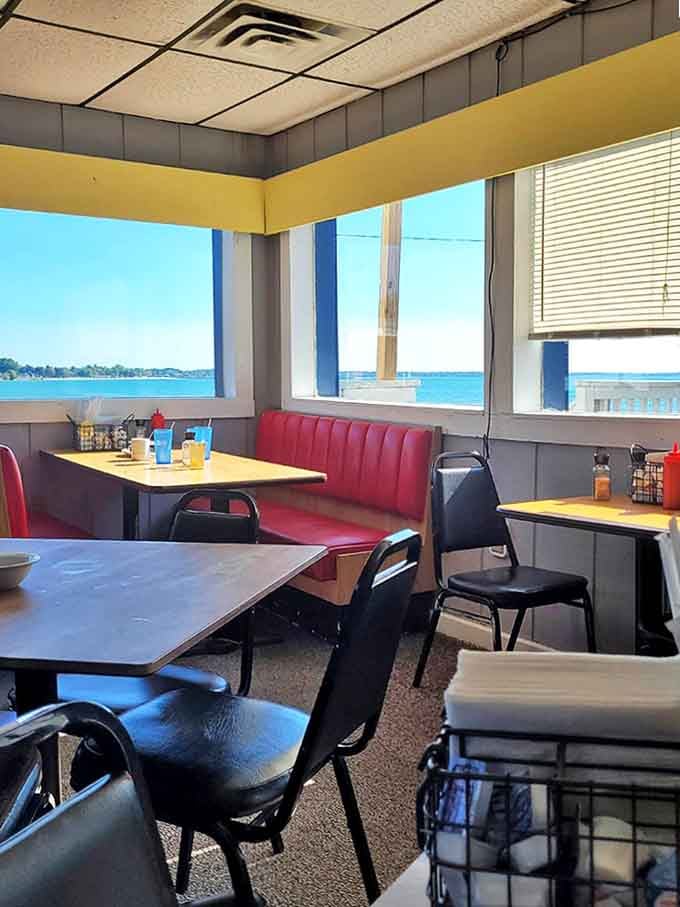 Window seats worth fighting for – red booths positioned perfectly to catch both the morning light and those hypnotic Lake Huron views.
