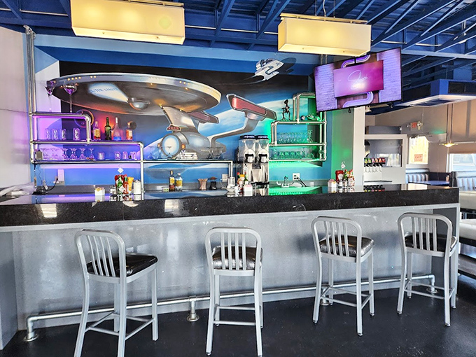 The bar area features sleek design elements and cosmic backdrops, serving up drinks with names that would make NASA blush.