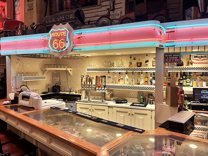 The Route 66 bar glows with neon promise, offering local craft beers and classic cocktails beneath the iconic highway shield.