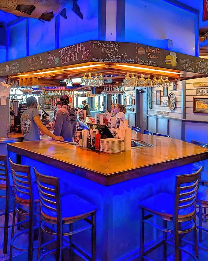 Blue-lit mixology magic happens here&mdash;where local brews flow and cocktail shakers dance to create liquid companions for your maritime feast.