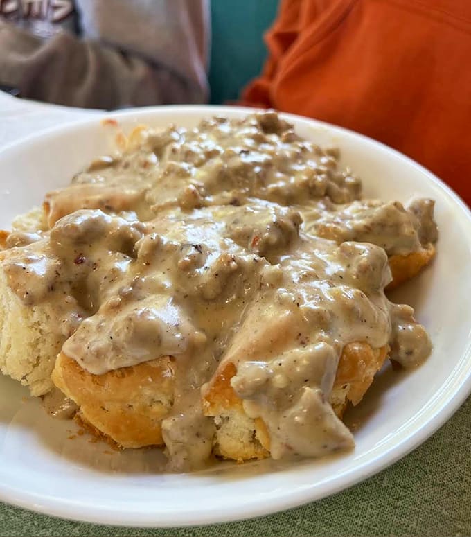 Those fluffy biscuits drowning in creamy sausage gravy represent comfort food at its finest and most unapologetic.