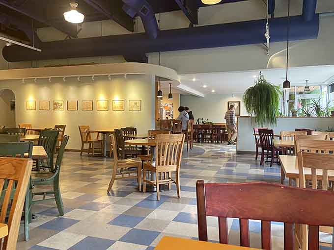 Multiple seating areas and soaring ceilings create an open, gallery-like atmosphere where breakfast feels like a cultural experience.