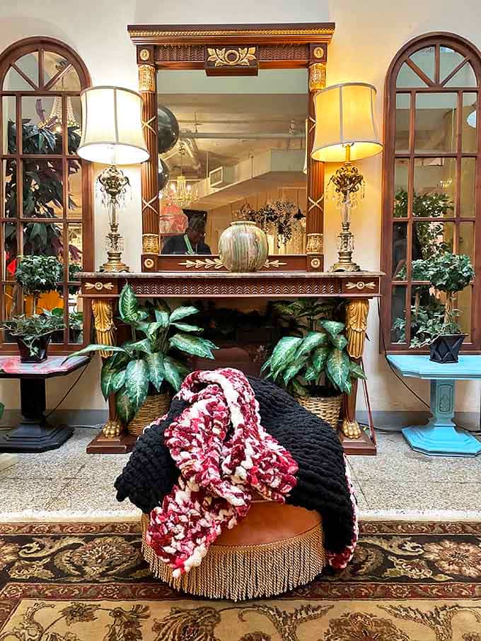 Regal refinement meets perfect symmetry in this elegant console display flanked by arched windows and crowned with golden details.