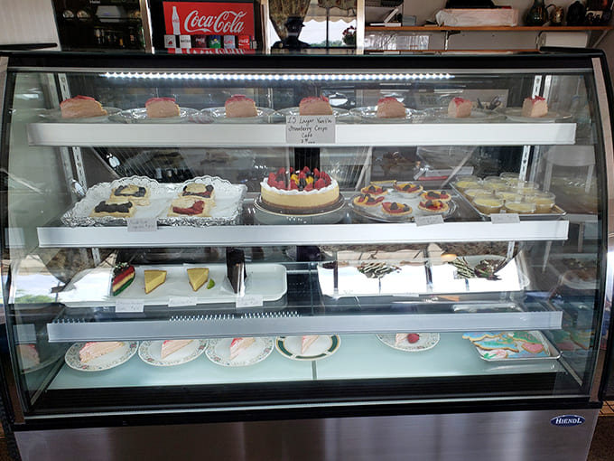 The dessert case displays its sweet treasures like edible jewelry, each slice calling your name louder than the last.
