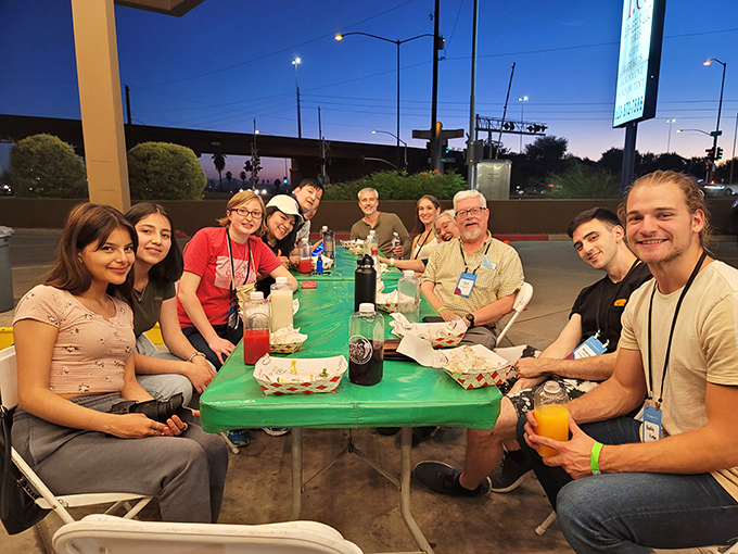 Diners: Night falls but the crowd remains, drawn together by the universal language of exceptional street food under twinkling lights.