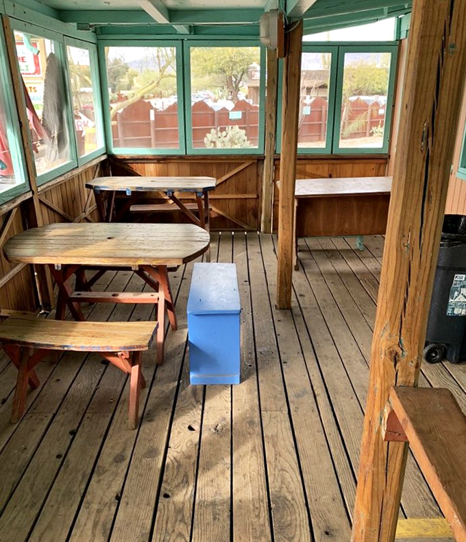 The screened porch dining area offers a breezy desert experience, where wooden tables have supported countless happy meals through the years.