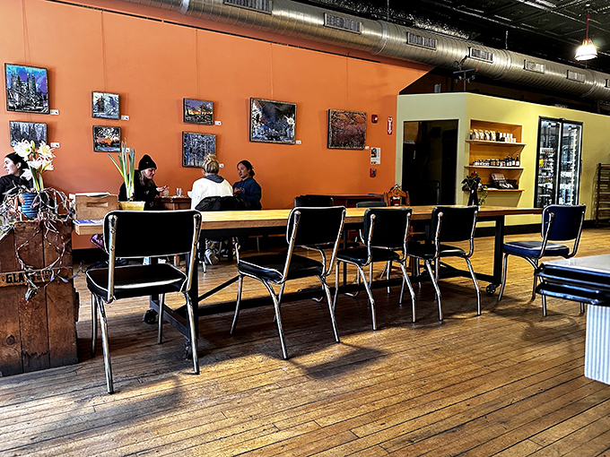 The dining area invites lingering, with its mix of seating options, warm colors, and natural light streaming through front windows.