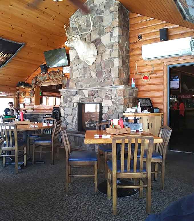 The stone fireplace serves as the heart of the dining room, radiating warmth both literal and figurative throughout the space.