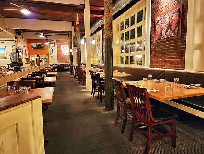 Cozy booth seating invites intimate conversations and lingering meals. The warm lighting makes everyone look like they're in a food commercial.