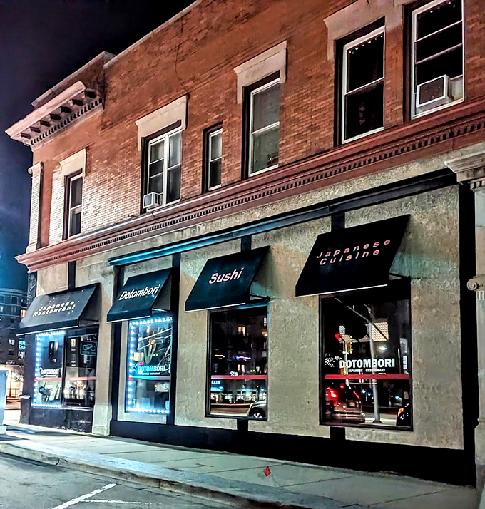 After sunset, the storefront glows like a beacon for sushi lovers, with neon signs promising Japanese delights within.