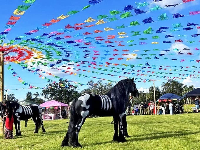 Colorful papel picado flags flutter above magnificent horses during one of Plant City's community celebrations that showcase local culture.