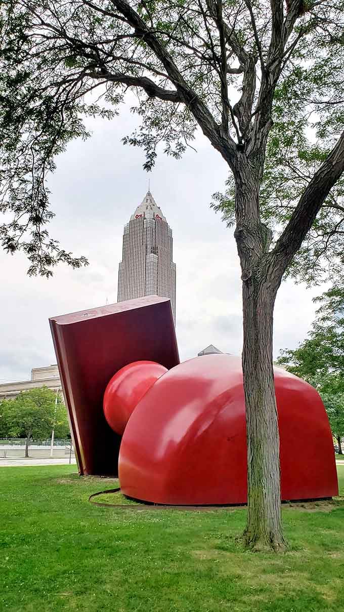 The sculpture's massive scale becomes apparent when viewed from behind, with downtown Cleveland's skyline providing a perfect urban backdrop.