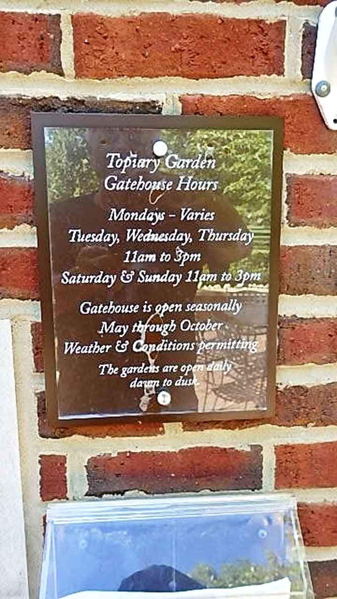 Seasonal hours posted on brick remind visitors that even living art needs its winter rest – plan accordingly!