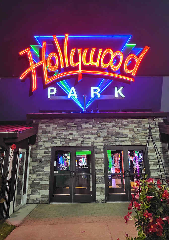 The neon glow of Hollywood Park's sign illuminates the night, promising evening adventures as exciting as daytime thrills.