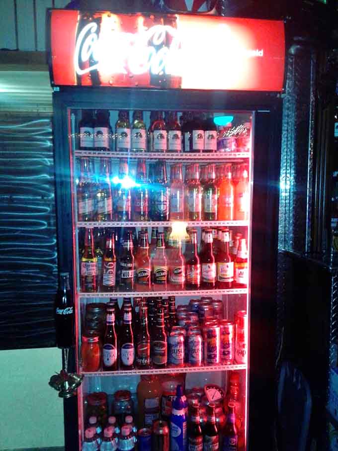 That glowing cooler full of cold beverages stands ready like a beacon of refreshment, calling to thirsty patrons after a long day.