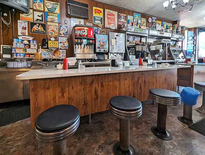 The counter where coffee flows freely and conversations happen naturally, offering front-row seats to the griddle magic happening behind the scenes.