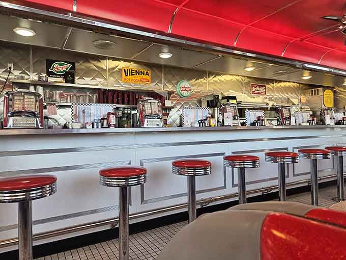 The long counter with chrome stools offers prime seating for milkshake enthusiasts and people-watchers alike, pure diner perfection.