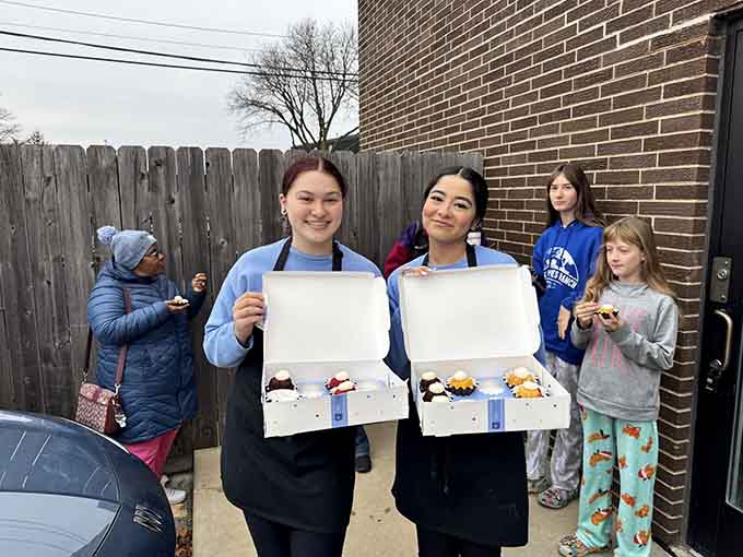 Happy staff members show off boxes of bundtlets, probably heading to make someone's day significantly better.