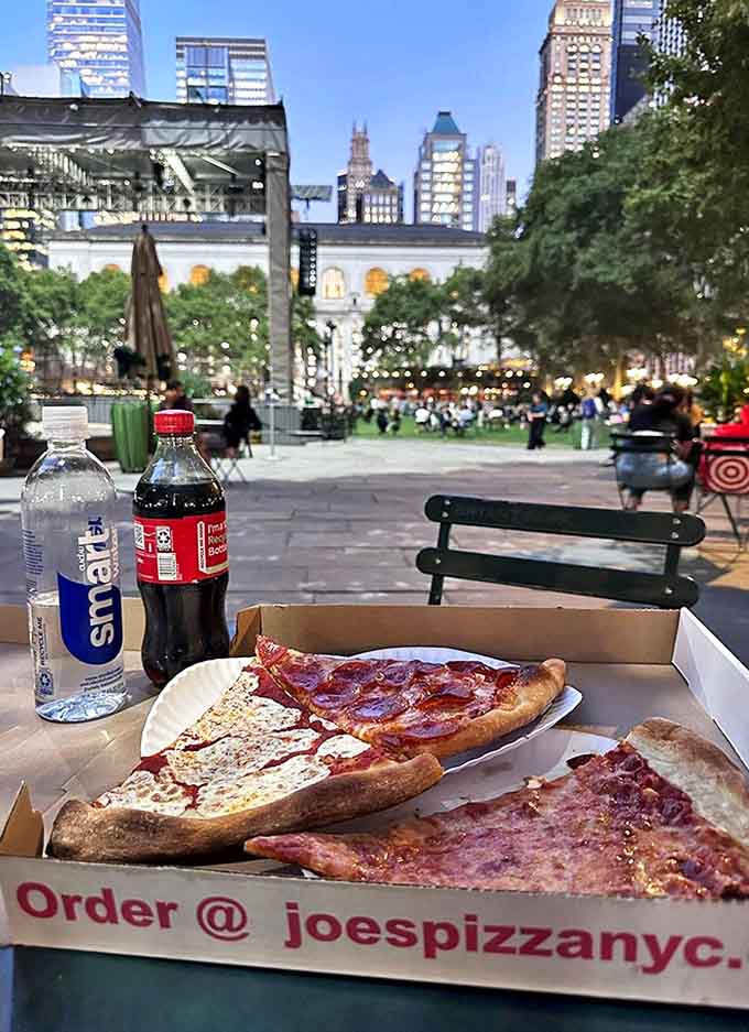 Pizza with a view: enjoying Joe's slices in Bryant Park proves that outdoor dining elevates the experience &ndash; urban oasis meets culinary bliss.
