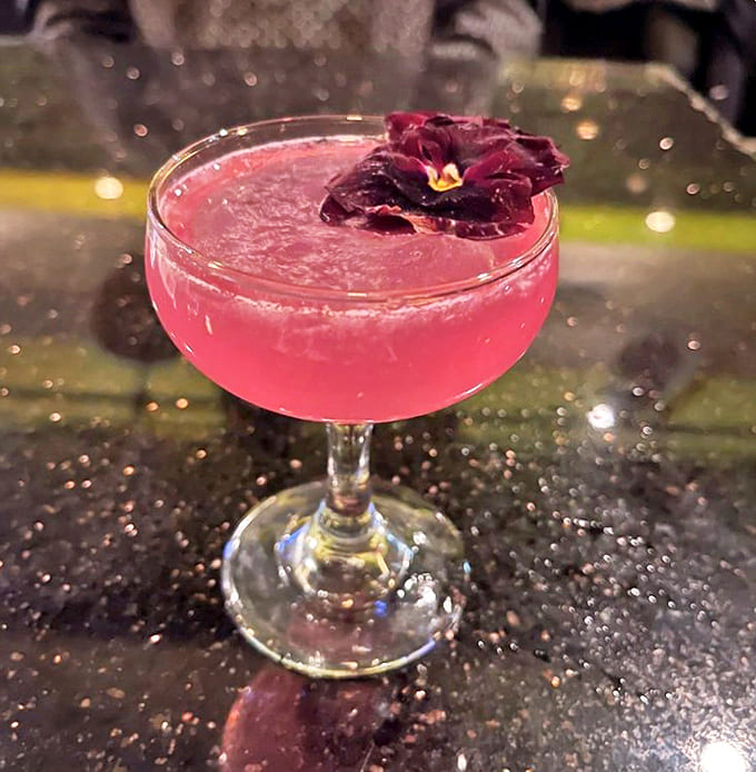 This vibrant cocktail isn't just a pretty face &ndash; it's a balanced blend of flavors, garnished with an edible flower for dramatic flair.