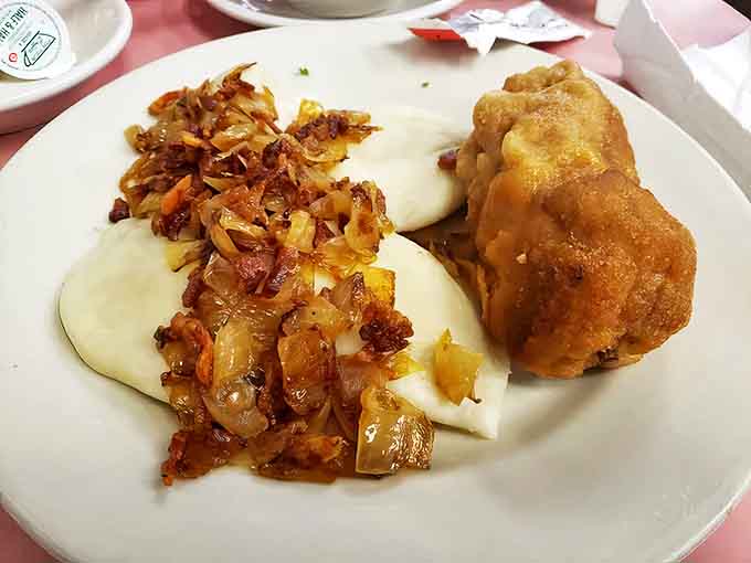 Golden-fried pierogi topped with caramelized onions—little pockets of potato perfection that could start a family feud over the last one.