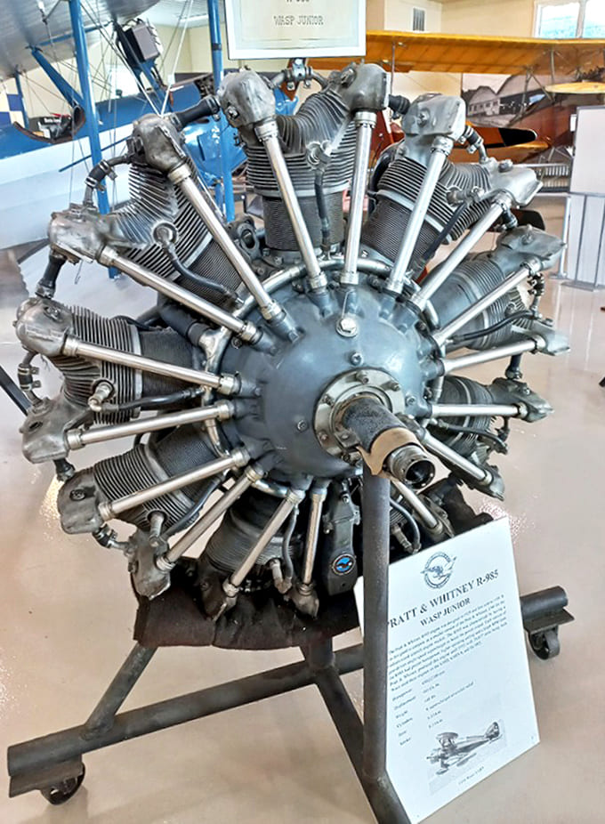 The Pratt & Whitney R-985 Wasp Junior engine sits like a mechanical sunburst, its radial design creating that distinctive rumble that defined an era of flight.