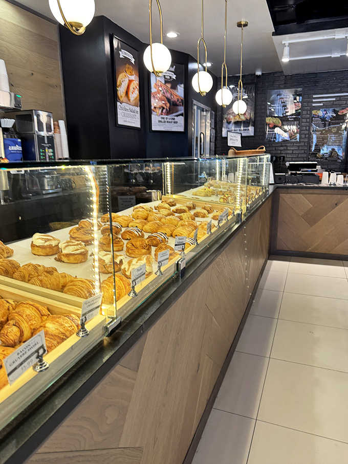Golden treasures behind glass: The display case showcases rows of perfectly laminated pastries waiting to make someone's day infinitely better.