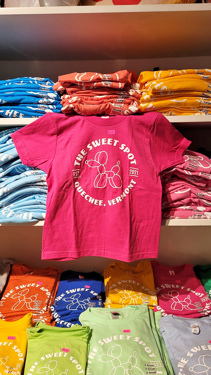 Vibrant t-shirts in rainbow hues proudly display The Sweet Spot's Quechee heritage. The perfect souvenir for when you've eaten all the evidence of your candy shop visit.