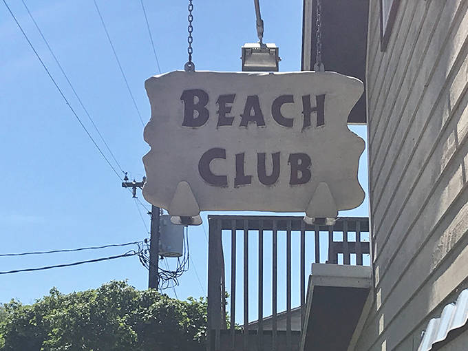 The weathered sign swings gently in the lake breeze, a beacon for hungry travelers seeking authentic Wisconsin island cuisine.