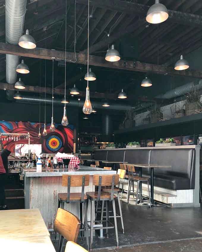 High ceilings and industrial lighting create a space that feels both expansive and intimate, where conversations flow as freely as the drinks.