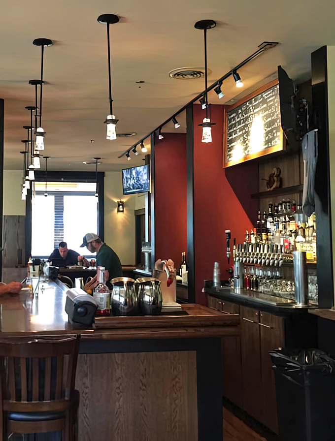 Modern pendant lighting casts a warm glow over the bar, where craft beers flow from taps showcasing Vermont's brewing prowess.