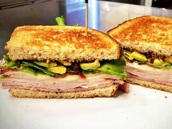Layer upon layer of thinly sliced turkey, crisp bacon, and fresh avocado create a club sandwich that towers over ordinary lunch options.
