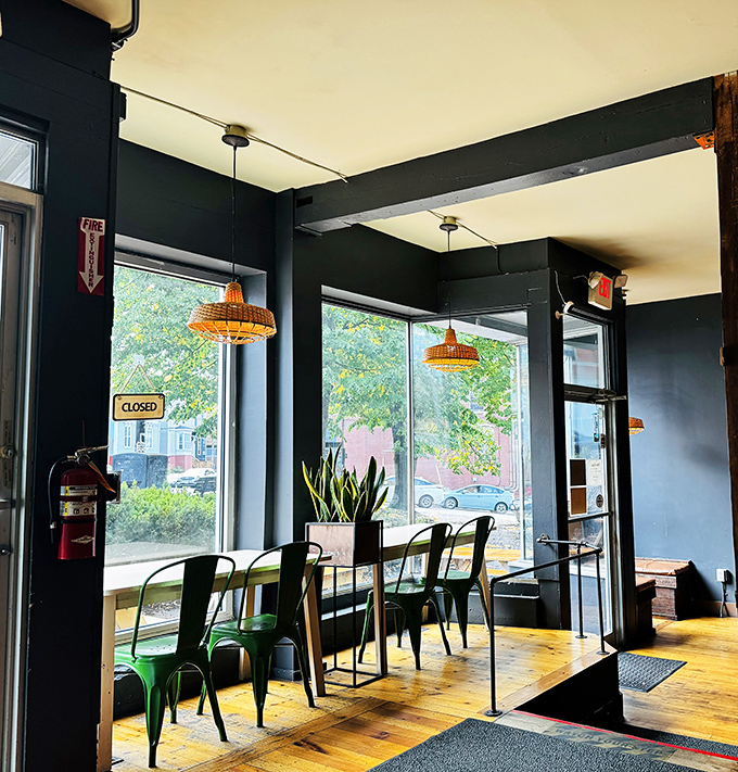 Window Seat: Natural light floods this cozy corner, where green metal chairs and wooden counters create the perfect perch for people-watching.