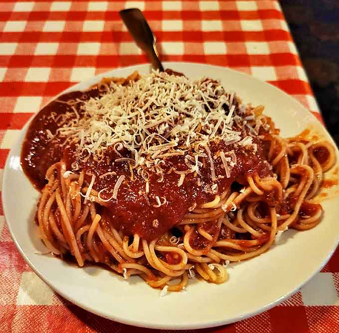 Simple yet profound &ndash; angel hair pasta embraced by a rich bolognese that whispers of hours spent simmering to perfection, crowned with freshly grated cheese.