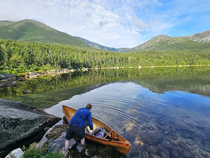 A wooden canoe waits patiently at the shoreline, ready to silently glide across waters that hold the sky's reflection.