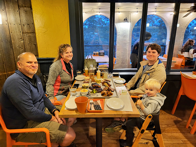 Happy diners gather around a table laden with barbecue treasures, creating memories one cornbread muffin at a time.