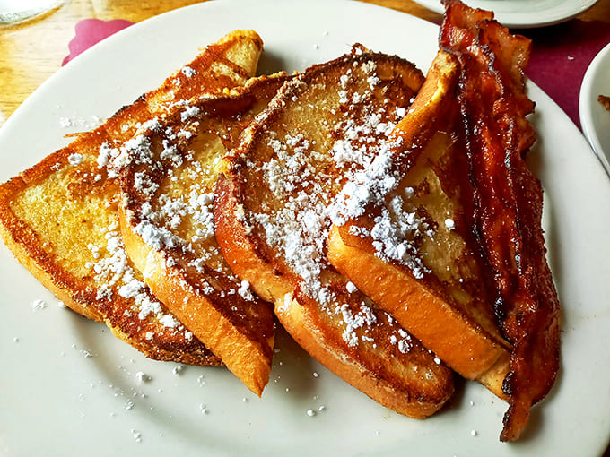 French toast that's achieved the perfect golden crust, with powdered sugar falling like the world's most delicious snowfall.