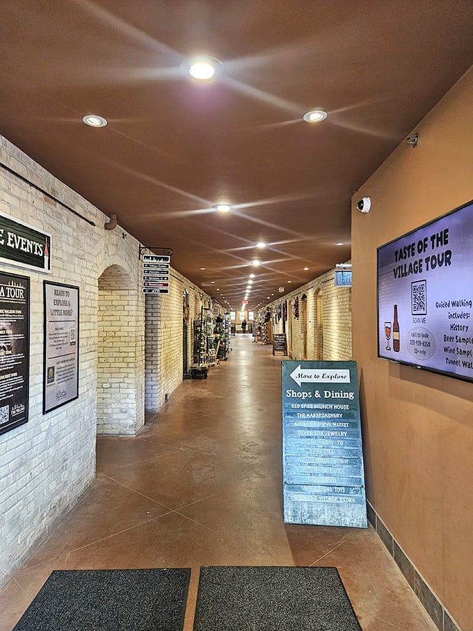 The renovated hallway's warm lighting and exposed brick create an inviting shopping corridor where boutiques and galleries have replaced hospital wards.