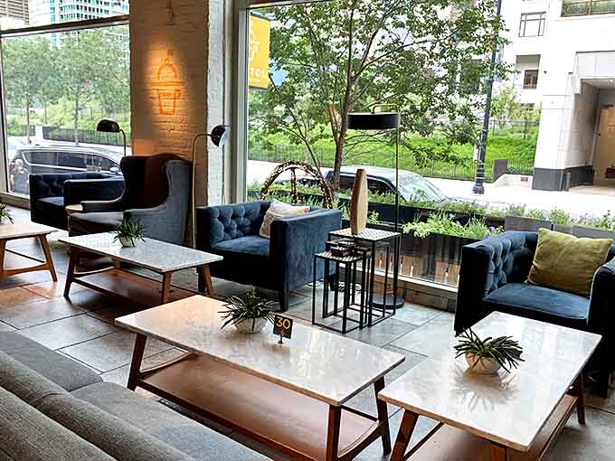 Sunlight streams through windows onto marble tables, creating the perfect Instagram moment nobody has to stage.