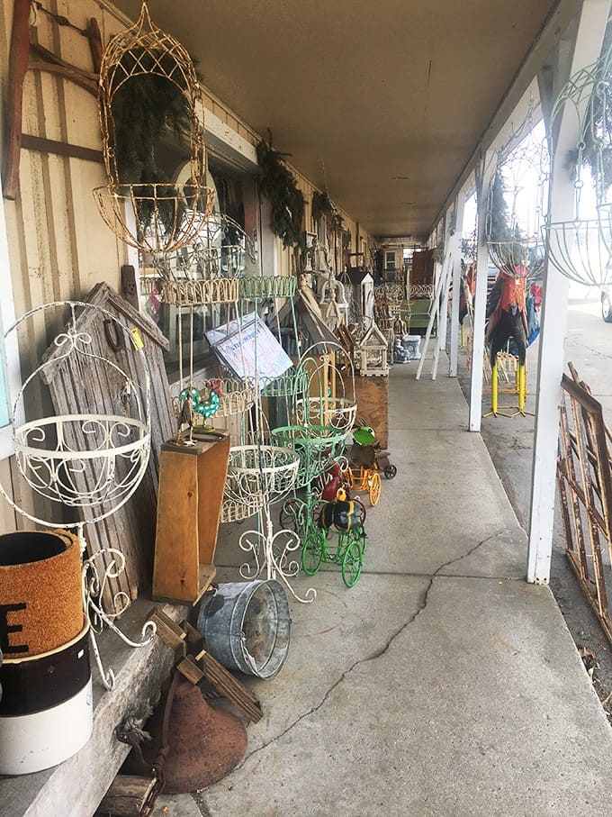 The outdoor walkway showcases an array of garden treasures &ndash; wrought iron planters with graceful curves waiting to enhance patios and garden spaces.