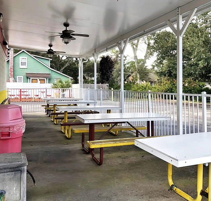 The covered patio offers a perfect sanctuary for ice cream contemplation, where ceiling fans keep both you and your dessert cool.