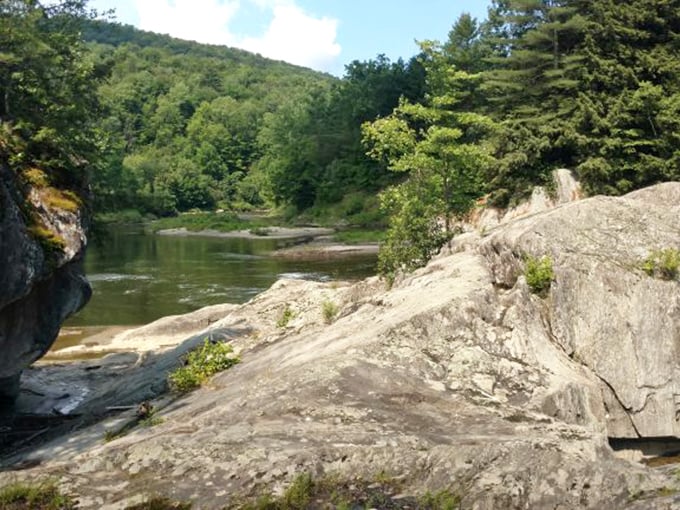 Ancient rock formations along riverbanks reveal Vermont's geological story, carved by water and time into natural sculptures.
